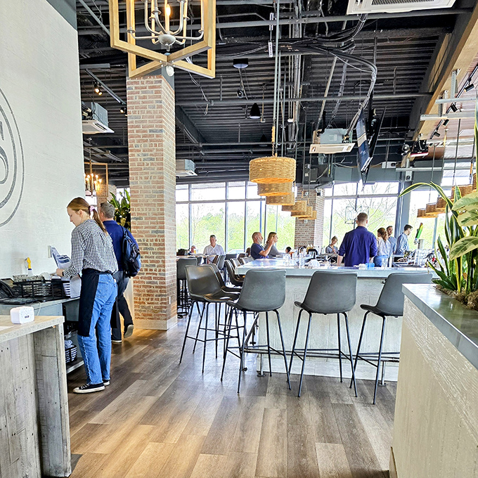Industrial-chic meets warm hospitality with exposed brick, wicker pendants, and those floor-to-ceiling windows that flood the space with natural light.