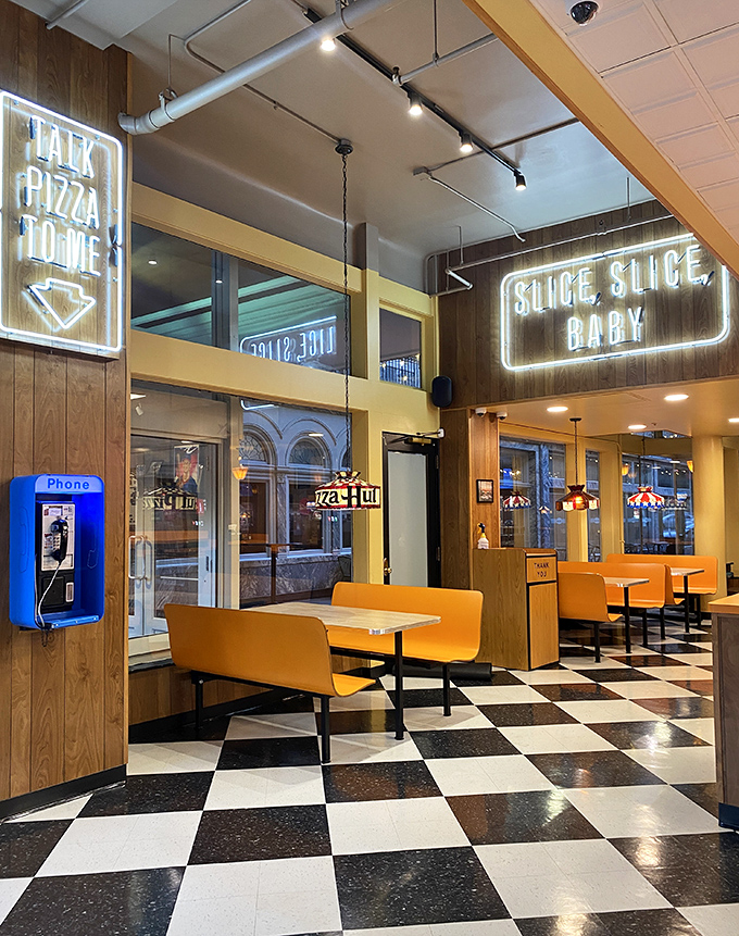 "Slice, Slice, Baby" isn't just clever neon&mdash;it's a philosophy. The retro checkered floor and orange booths create pizza's perfect backdrop.