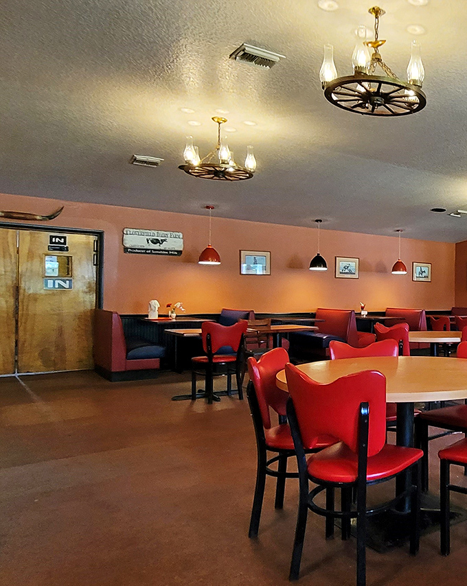 Wagon wheel chandeliers and cherry-red chairs create that perfect "come as you are, stay as long as you want" vibe.