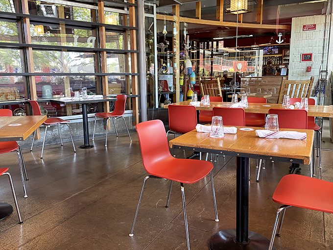 Red chairs pop against wooden tables in this airy interior, creating the perfect backdrop for seafood feasts that transport you straight to coastal New England.