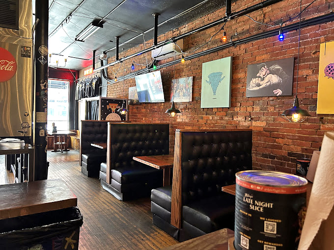 Exposed brick walls and Edison bulbs create the perfect atmosphere where great pizza meets genuine neighborhood warmth.