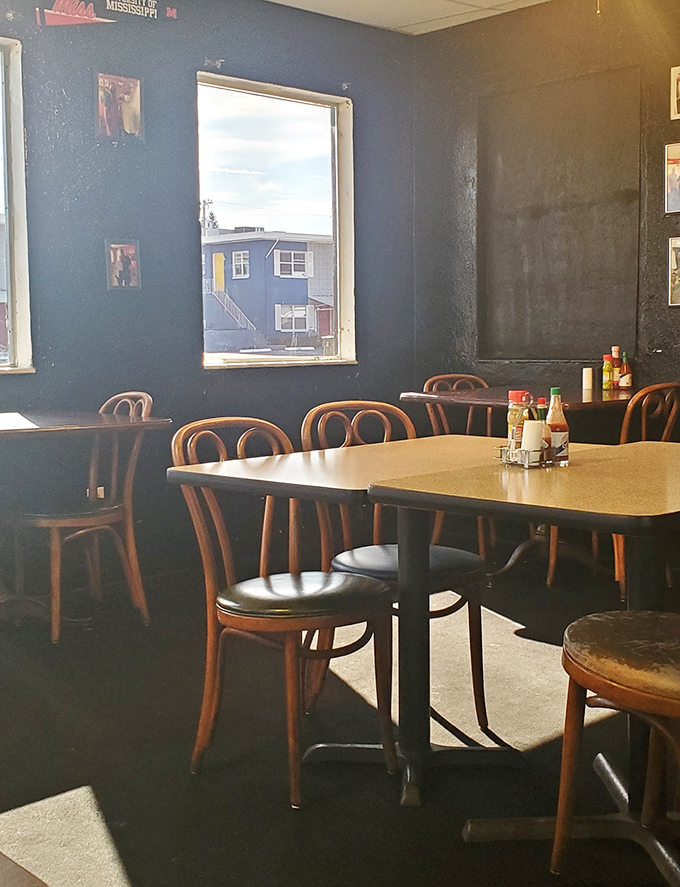 Simple tables, wooden chairs, and dark walls create the perfect stage where smoked meat becomes the undisputed star of the show.
