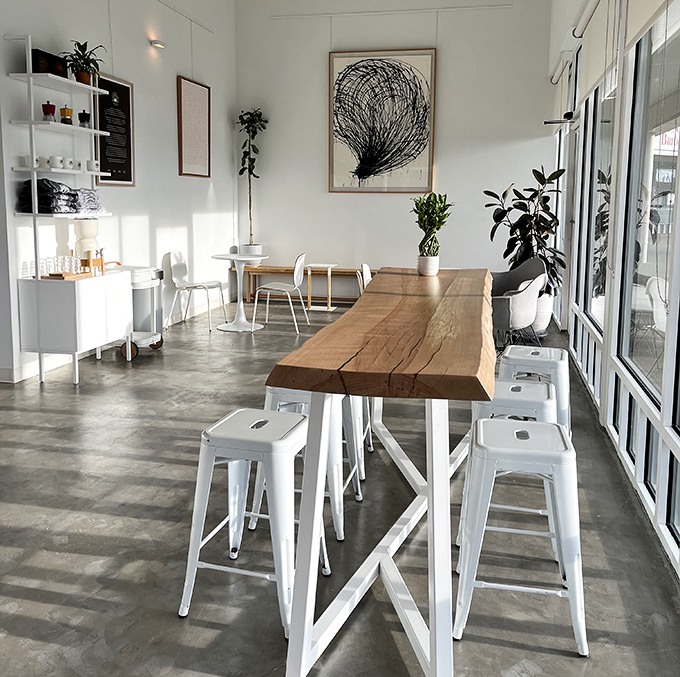 A Scandinavian-inspired sanctuary where dessert becomes meditation. That live-edge communal table invites strangers to become temporary neighbors over coffee.