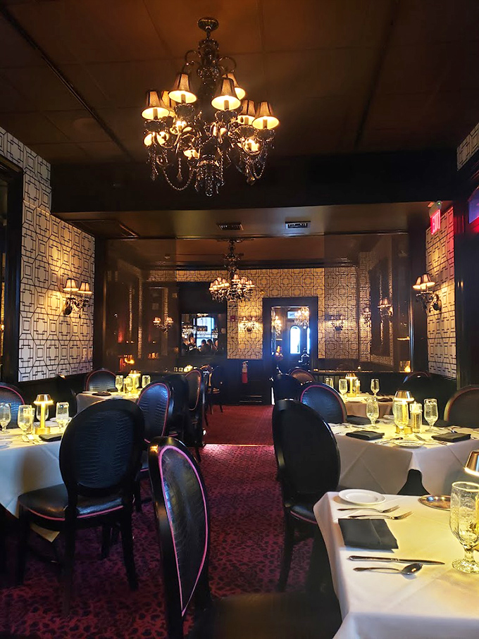 Crystal chandeliers cast a golden glow over white tablecloths and burgundy upholstery&mdash;dining rooms like this make Tuesday night feel like your anniversary.