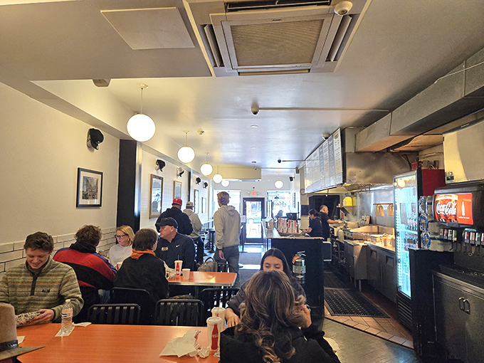 Inside Sonny's, the clean, bright interior with globe pendant lights creates the perfect stage for cheesesteak drama to unfold.