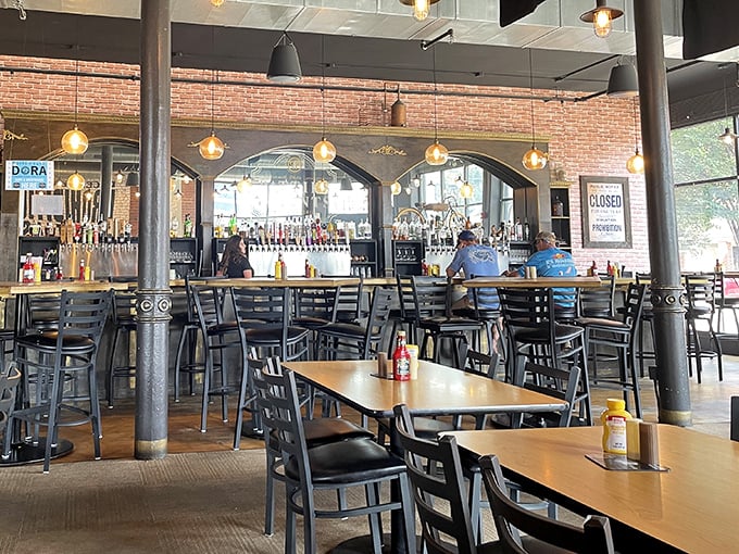 Industrial-chic meets comfort at the bar, where exposed brick and pendant lighting create the perfect backdrop for serious burger contemplation. 