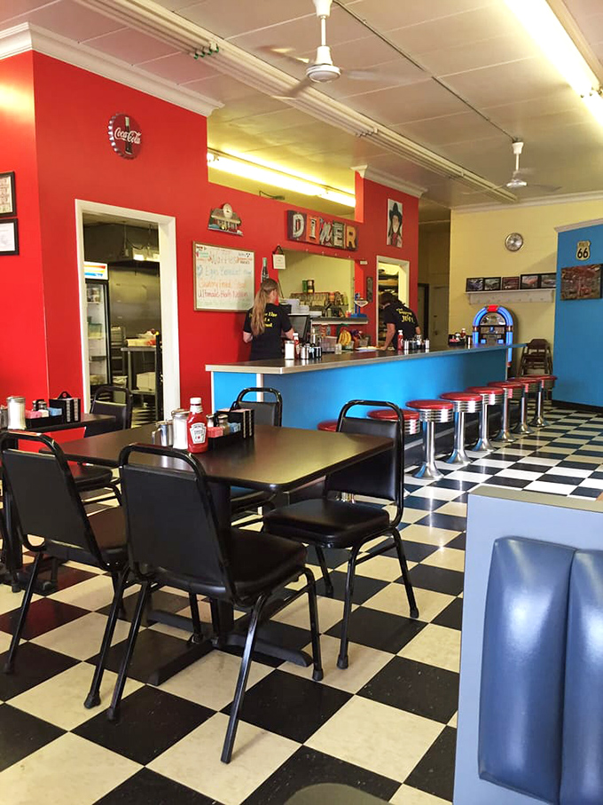 Classic Americana comes alive inside with that iconic checkered floor, vibrant red walls, and blue counter that feels like stepping into a Norman Rockwell painting come to life.
