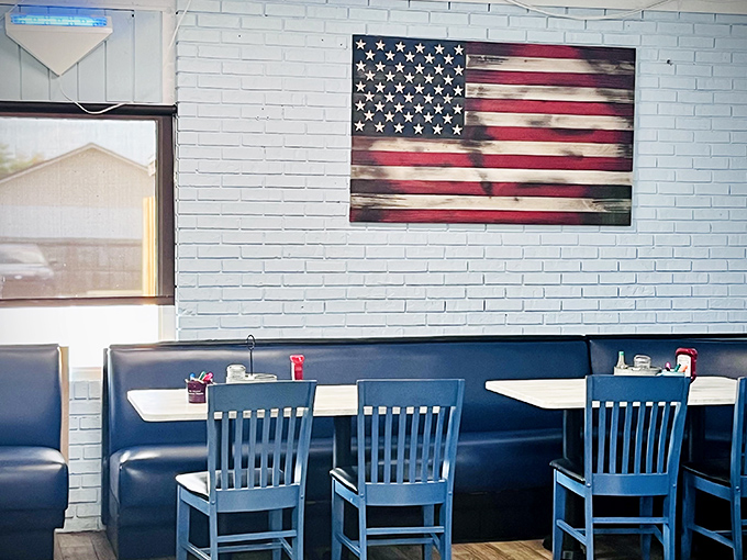 Classic diner charm meets Florida comfort with blue booths, wooden tables, and that weathered American flag that's witnessed countless breakfast celebrations.