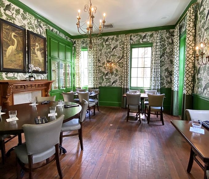 Step into the Green Room, where vibrant wainscoting and botanical wallpaper create a dining space that feels like a secret garden indoors.