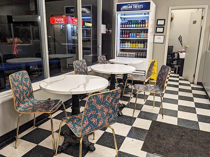Classic black and white checkered floors set the stage for sweet decisions. The mid-century modern seating area invites you to savor your treats immediately.