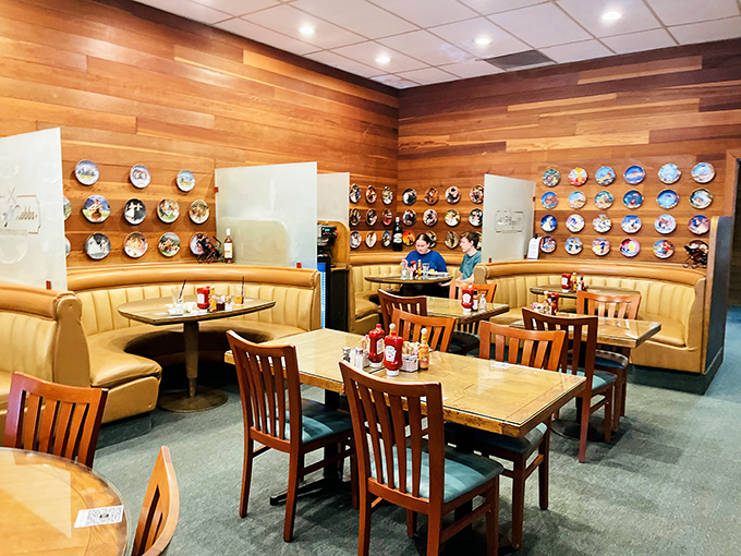 The decorative plate collection isn't just wall decor&mdash;it's a museum of American dining history, watching over comfortable booths where countless conversations have unfolded.