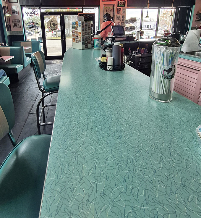 The mint-green counter whispers tales of countless coffee refills and life-changing breakfast decisions made in these vintage chairs.