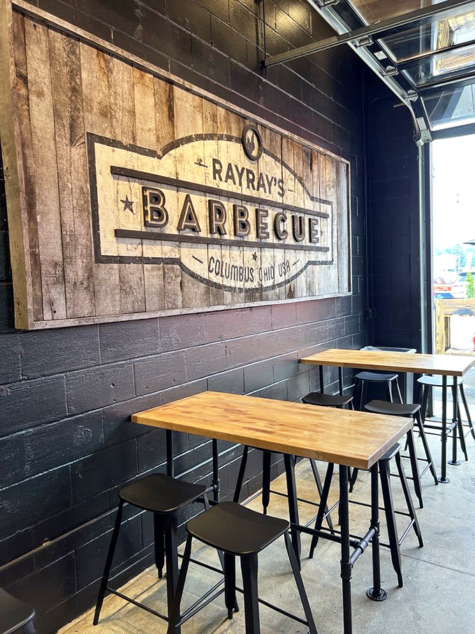 Simple wooden tables against industrial black walls &ndash; Ray Ray's dining area isn't about fancy frills, it's about creating the perfect stage for the real star: that magnificent barbecue.