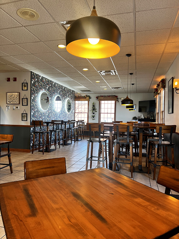Modern pendant lighting meets cozy wooden tables in a space that whispers "stay awhile" rather than shouting "eat and run."