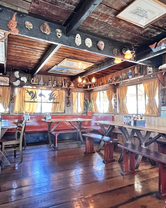 Masks watch over diners from wooden walls while yellow curtains frame marina views. This isn't Pinterest-perfect nautical&mdash;it's the authentic article.