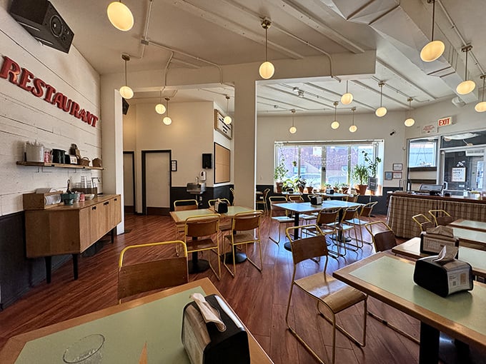Minimalist chic meets comfort in this bright, airy dining room. Pendant lights cast a warm glow over wooden tables where chicken dreams come true.