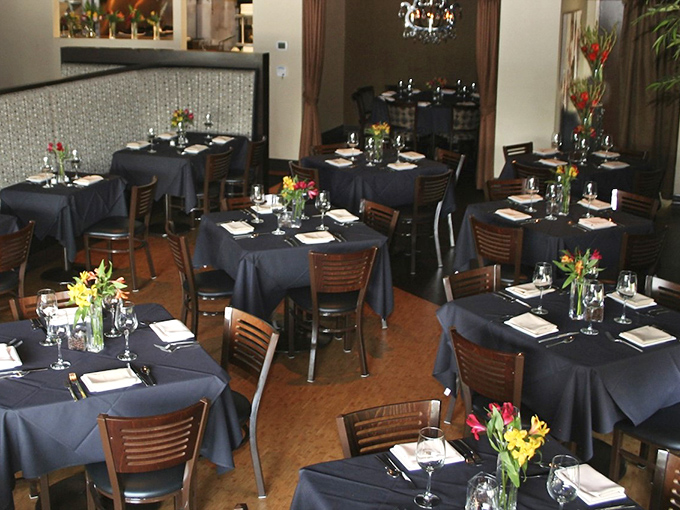 Navy tablecloths, wooden chairs, and fresh flowers create that perfect "fancy but not intimidating" vibe where both first dates and anniversaries thrive.