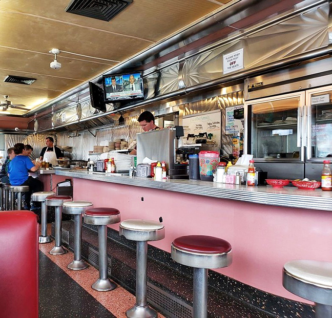 Pink countertops and chrome stools line up like loyal soldiers, ready for the next wave of hungry patrons seeking comfort food salvation.