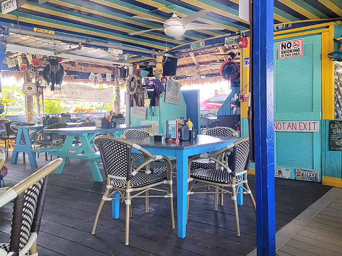 Colorful chaos that somehow works perfectly. Blue tables, striped ceiling beams, and "NOT AN EXIT" signs create the kind of place where vacation memories are born.
