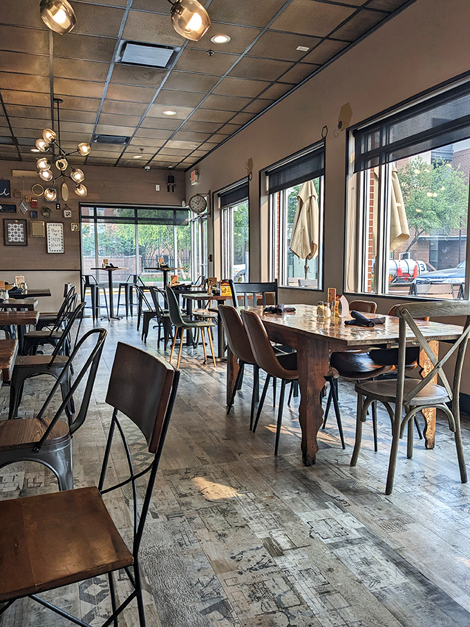 Mismatched chairs, weathered wood tables, and that statement lighting fixture create the perfect backdrop for the food drama about to unfold on your plate.