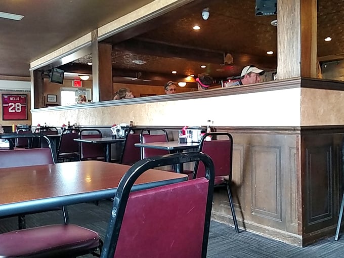 Classic burgundy chairs and wooden accents create that perfect small-town diner atmosphere where conversations flow as freely as the coffee.