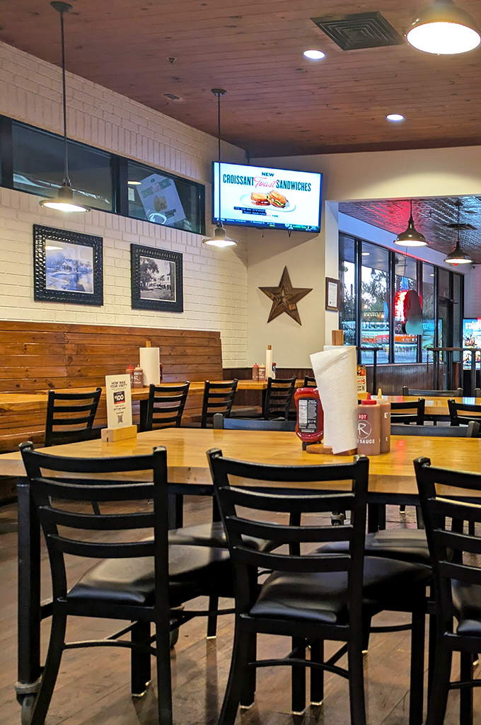 Wooden tables, metal chairs, and that warm ceiling create the perfect backdrop for the meat-centric magic about to unfold on your plate.