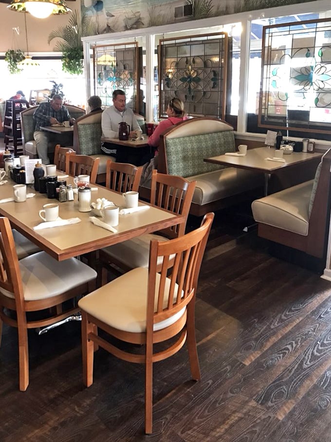 Stained glass windows filter morning light across wooden tables where breakfast dreams come true. Cozy booths invite you to settle in.