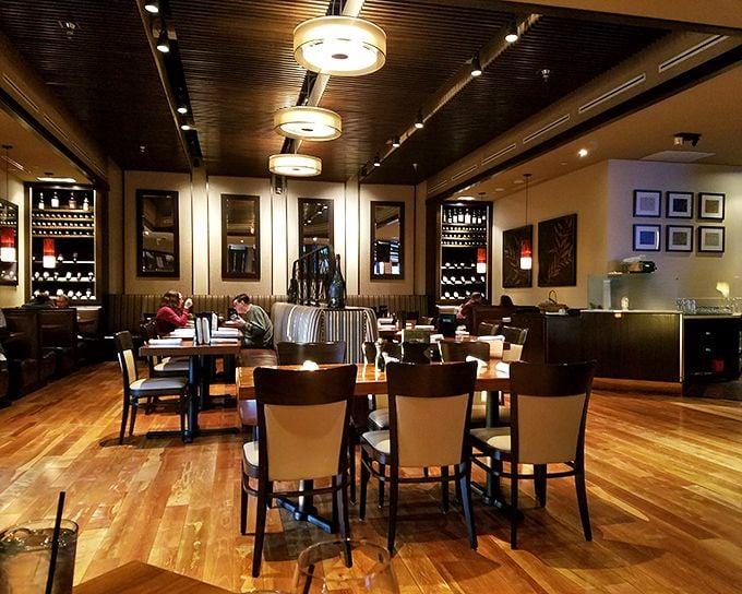 Sunlight streams through large windows, illuminating wooden chairs and terracotta tiles in a dining room where food, not decor, is the undisputed star.