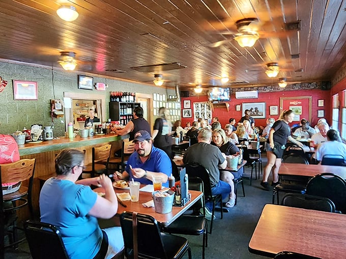 Inside, wood-paneled ceilings and vibrant red walls create the perfect backdrop for the real star: conversations that flow as freely as the drinks.
