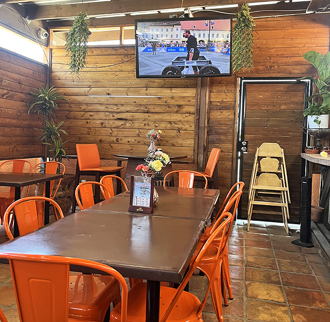Orange chairs pop against wooden walls in this no-nonsense dining room where comfort trumps trendiness and your taste buds reap the rewards.
