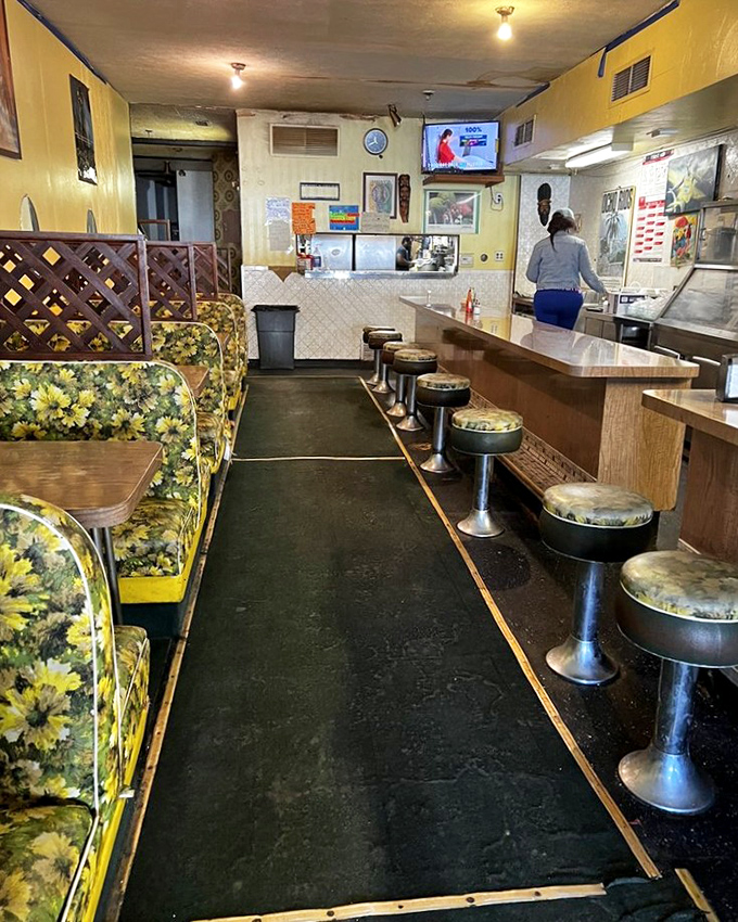 Vintage floral booths and classic counter stools create that perfect "neighborhood joint" vibe where culinary magic happens without pretense.