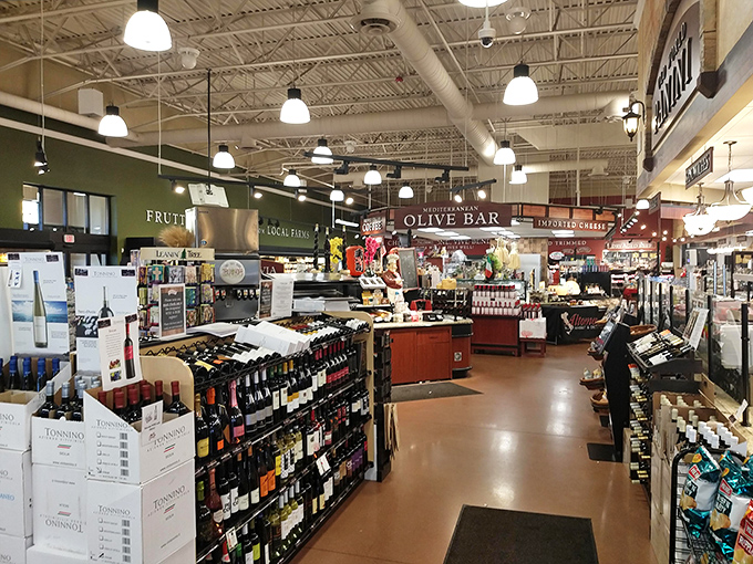 Wine bottles stand at attention like delicious soldiers, ready to march straight to your dinner table. The olive bar beckons with Mediterranean treasures.