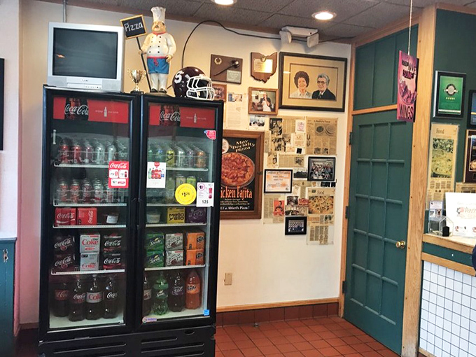 A shrine to pizza history adorns the walls, complete with a chef statue standing guard over the sacred Coca-Cola refrigerators.