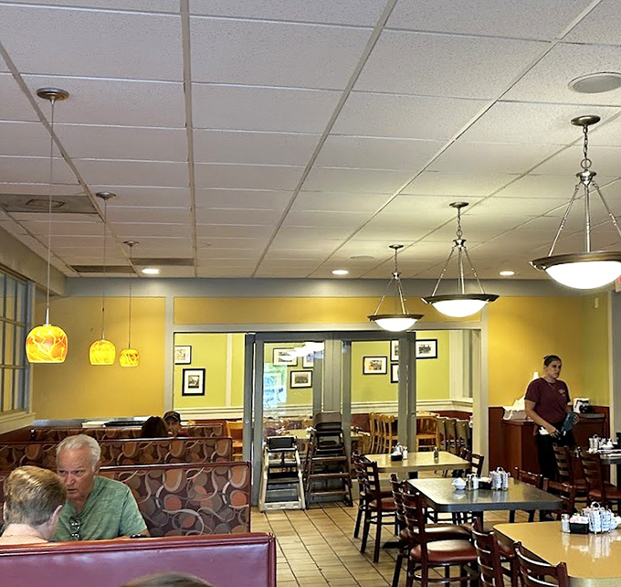 Warm yellow walls and cozy booths create that perfect diner atmosphere where conversations flow as freely as the coffee refills.