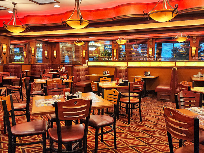 Warm wood paneling, burgundy booths, and amber lighting create that perfect diner atmosphere where memories are made and diet plans go to die.