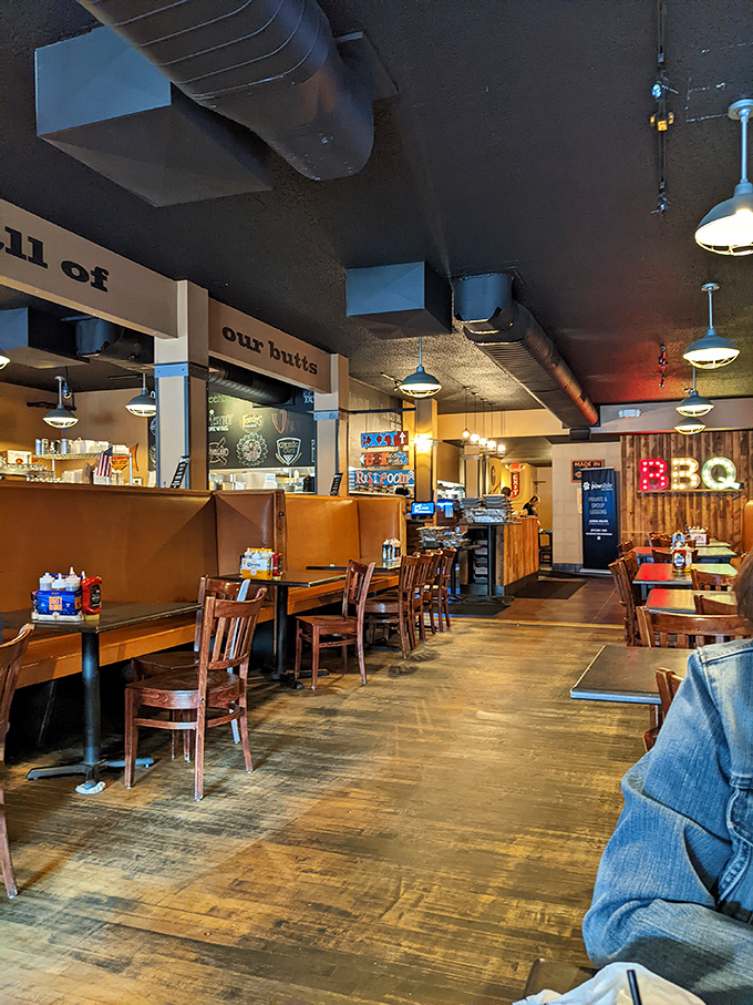 Where smoke meets soul. The rustic interior with its "all of our butts" sign proves this place has both serious barbecue credentials and a healthy sense of humor.