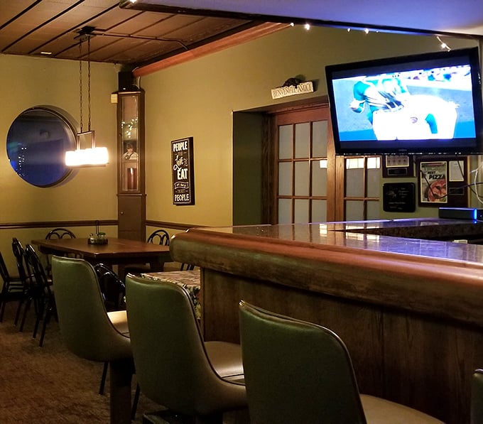 The cozy bar area offers the perfect vantage point for both sports watching and pizza anticipation. Wood paneling never went out of style here.