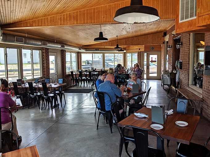 Wooden ceilings, industrial lighting, and the gentle hum of BBQ appreciation. This dining room feels like the living room of that friend who always hosts the best dinner parties.