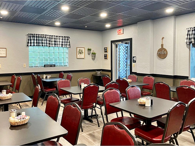 Classic red chairs and checkered curtains create that perfect small-town diner atmosphere where conversations flow as freely as the coffee refills.
