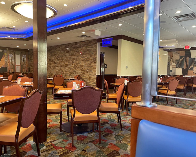 Blue accent lighting casts a cool glow over warm stone walls and comfortable seating, creating that perfect diner atmosphere where conversations flow as freely as the coffee.
