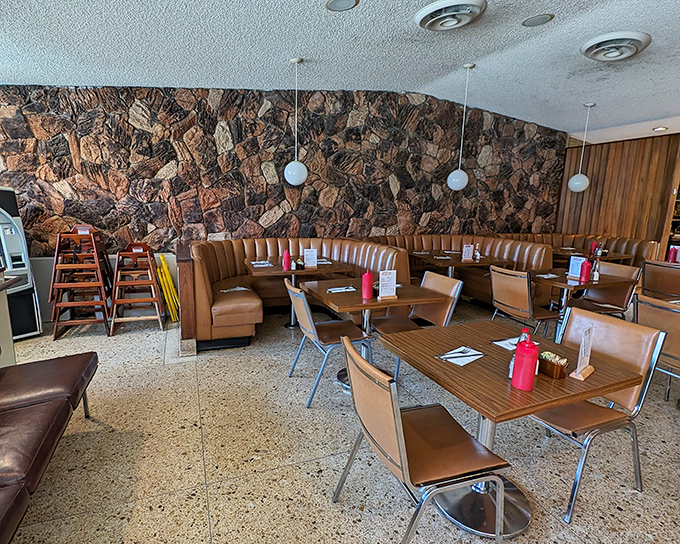 Mid-century magic meets breakfast bliss in these caramel-colored booths. The stone wall isn't just decor&mdash;it's practically a time machine to simpler days.