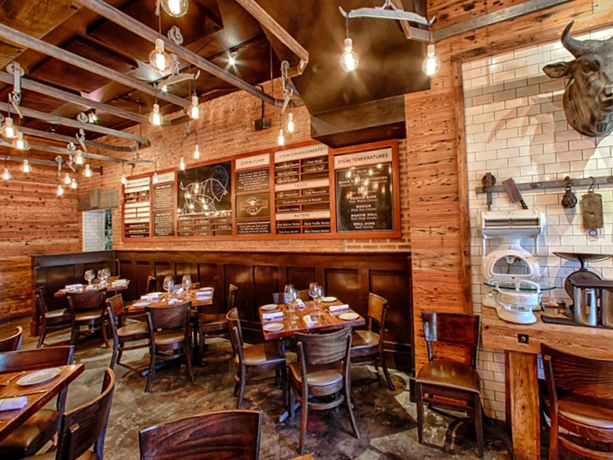 Rustic meets refined in this warm, wood-paneled dining room. Edison bulbs cast a golden glow over tables where carnivorous dreams come true.