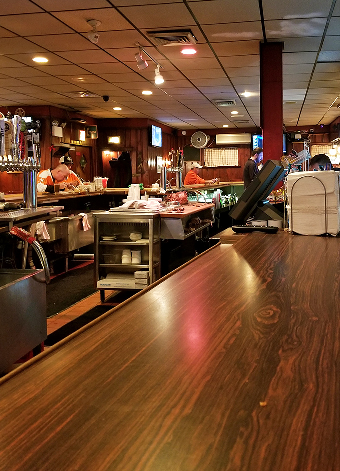 Behind the bar, where magic happens daily. This wood-paneled wonderland is where sandwich dreams come true and strangers become regulars.