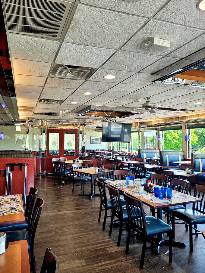 Inside, blue booths and warm wood tones create that perfect diner atmosphere where conversations flow as freely as the coffee refills.