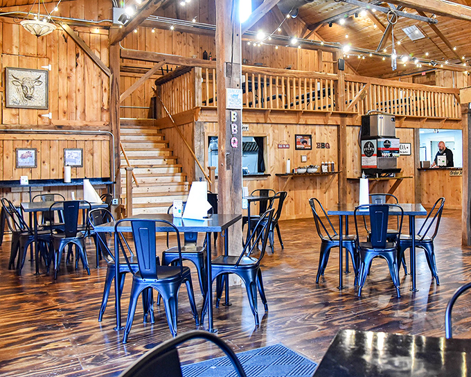 Rustic wooden beams meet modern blue chairs in this barn-turned-BBQ-sanctuary where comfort meets craftsmanship.