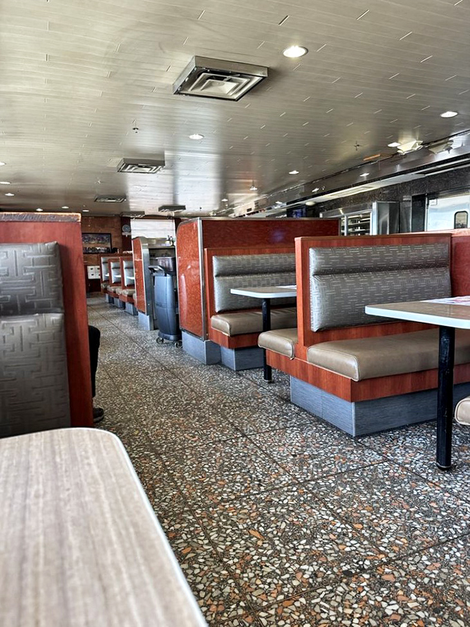 Classic diner booths await your stories, laughter, and inevitable food comas. The terrazzo floor has witnessed decades of satisfied customers.