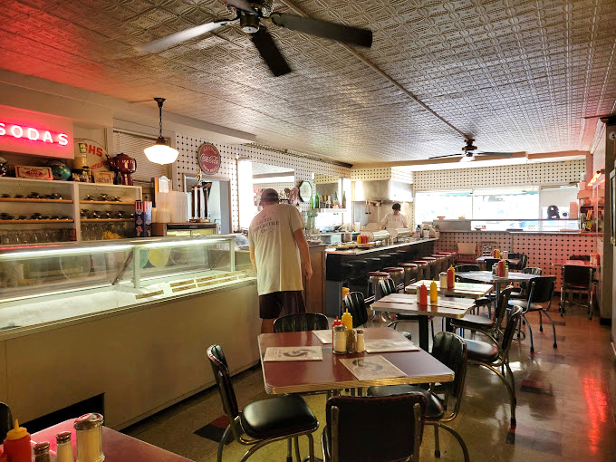Step inside and the pressed tin ceiling, vintage counter, and classic diner tables transport you to an era when conversations happened face-to-face instead of face-to-screen.