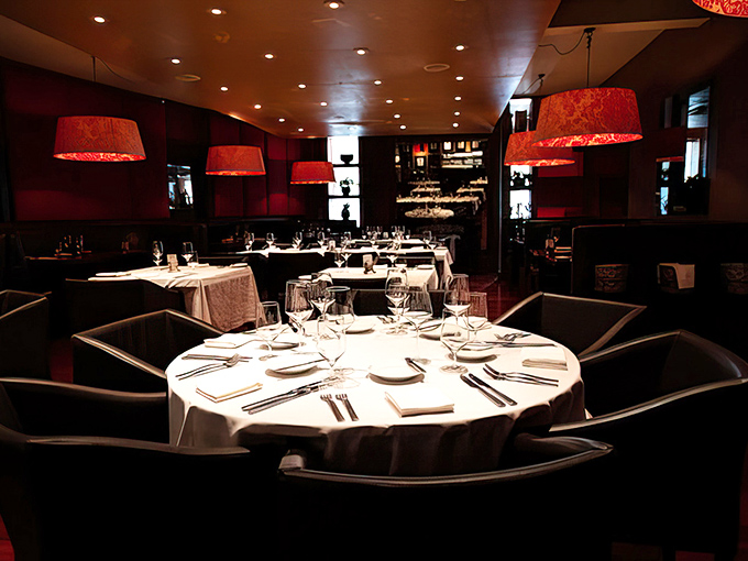 Those red lampshades cast the perfect glow for conversations that last well past dessert.