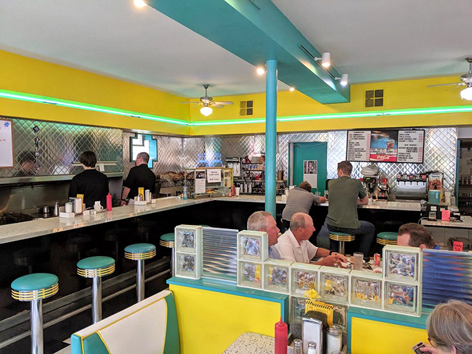 Inside, the diner's vibrant color scheme continues with turquoise accents and classic counter seating where regulars perch like birds on a wire.