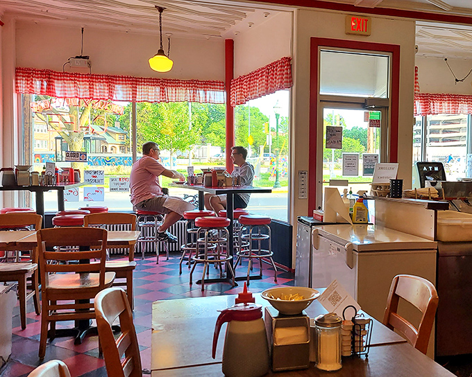 Red-checkered curtains frame a slice of authentic Madison life, where conversations flow as freely as the coffee in this sunlit corner of nostalgia.